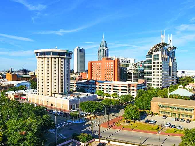 Mobile's downtown skyline showcases a beautiful mix of historic and modern buildings surrounded by lush Southern greenery and blue skies.