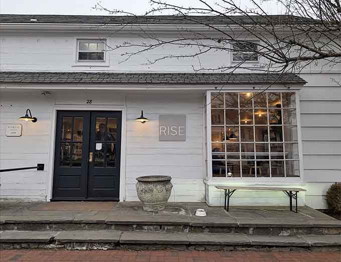 Clean white siding and warm lighting create an inviting atmosphere that whispers "treat yourself" in the nicest way.
