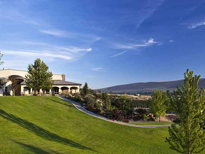 The elegant building crowns the hilltop like a Mediterranean jewel overlooking endless rows of perfectly tended grapevines below.