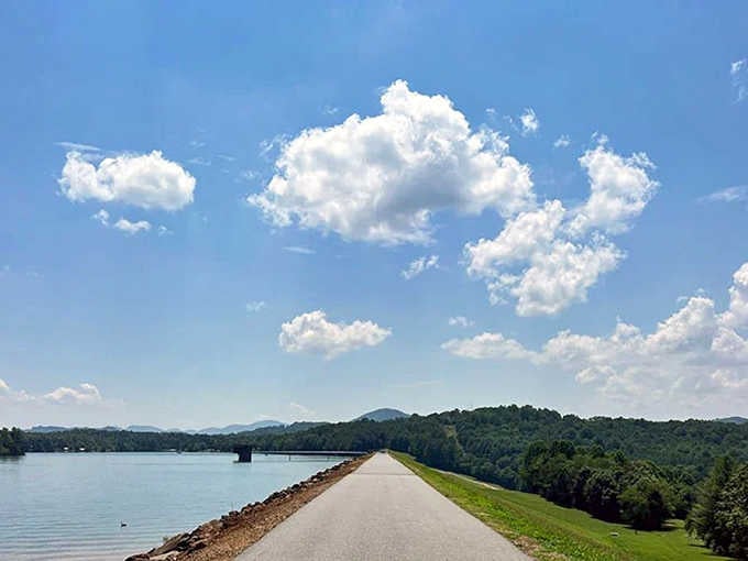 A ribbon of road stretching toward mountain silhouettes under billowing clouds&mdash;this is what postcards try to capture.