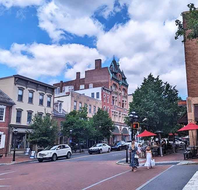 Families crossing brick-paved streets under dramatic skies capture the timeless appeal of a downtown that actually works for real people.