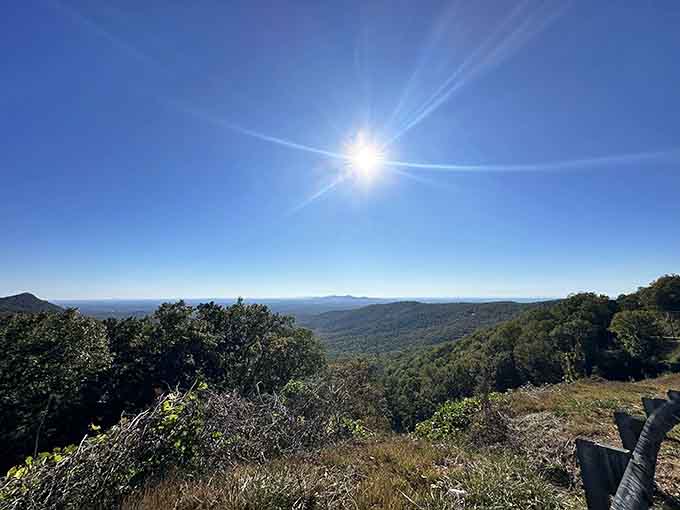 The sun blazes overhead like a spotlight on this endless mountain panorama where wilderness meets crystal-clear blue sky.