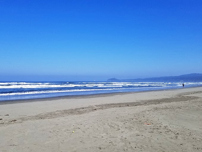 Perfect waves line up like they're auditioning for a surfing movie, with mountains providing the dramatic backdrop.