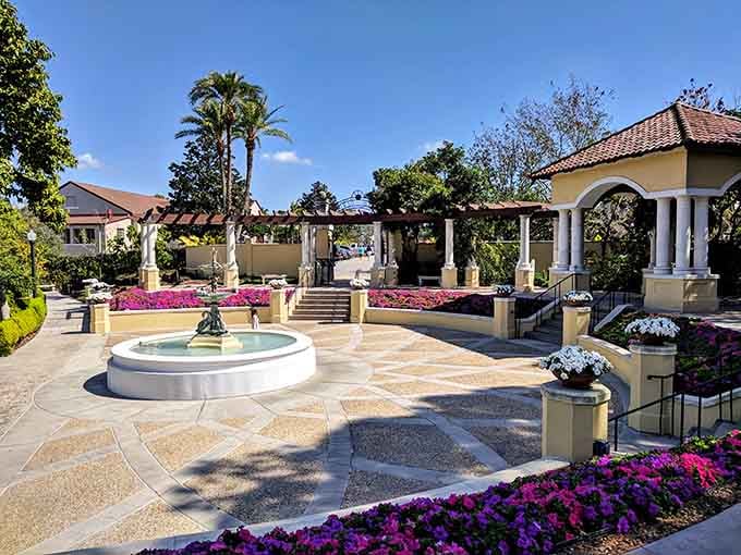 Purple blooms cascade around classical architecture proving that some gardens belong in fairy tales, not guidebooks.