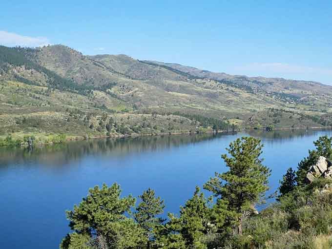 Those rolling hills mirror perfectly in blue water that stretches wider than your neighbor's fish stories.