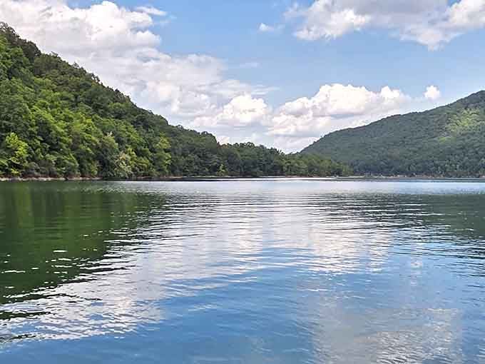 Cloud reflections dance across the water between forested peaks, painting a scene worthy of any gallery wall.