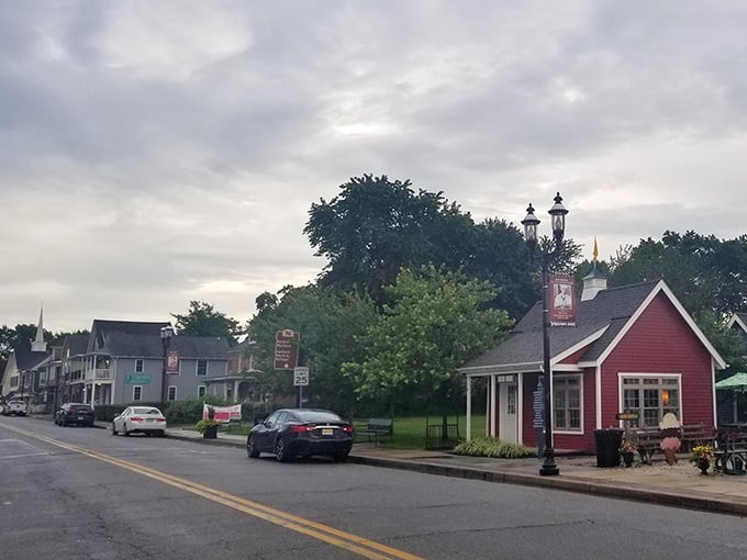 Cloudy skies cast a soft, muted glow over this charming red cottage, making it feel even more cozy and inviting.