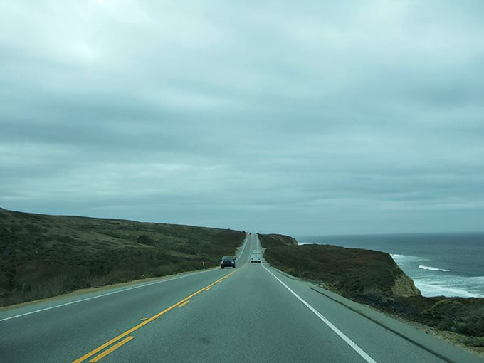 The road hugs the coastline under overcast skies, offering raw beauty that changes with every passing cloud.