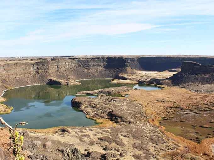 Dry Falls reveals its layered canyon walls and hidden lakes like chapters in Earth's autobiography.