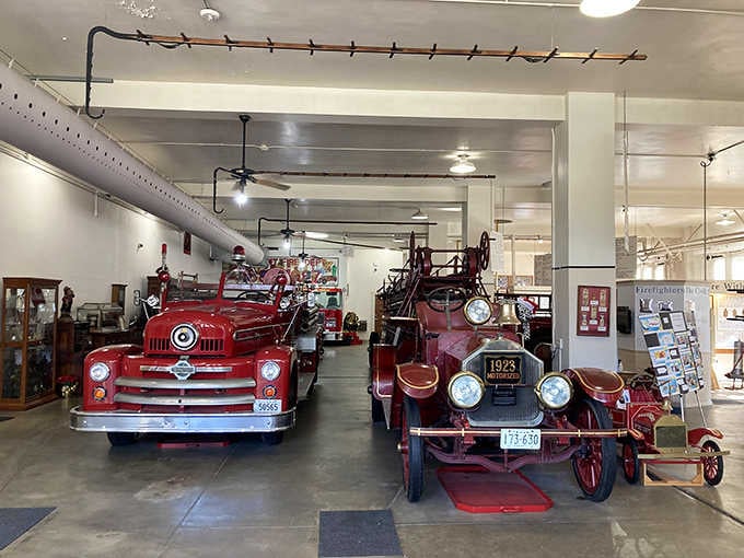 Gleaming red engines lined up inside showcase firefighting evolution from hand-pulled carts to powerful motorized heroes.