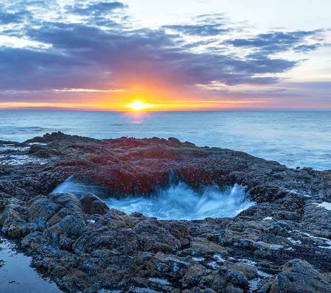 Sunset transforms this coastal phenomenon into a swirling masterpiece of light, mist, and raw Pacific power.