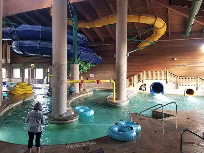 A sharp-eyed lifeguard stands watch beneath Three Bear's towering slide structure, where carved rock details and warm wood tones create surprisingly cozy drama.