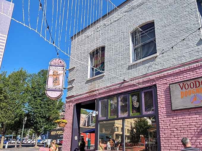 That iconic vertical sign dangles overhead like a beacon, drawing donut pilgrims from blocks away with its quirky charm.