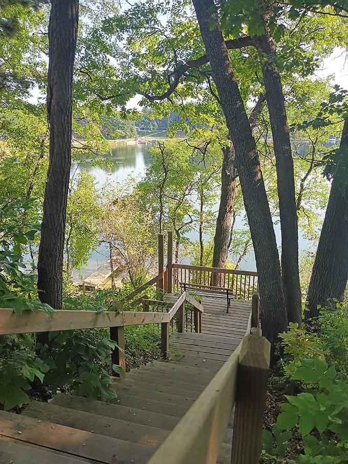Wooden stairs wind through towering trees toward the water, inviting you down to your own peaceful lakeside retreat.