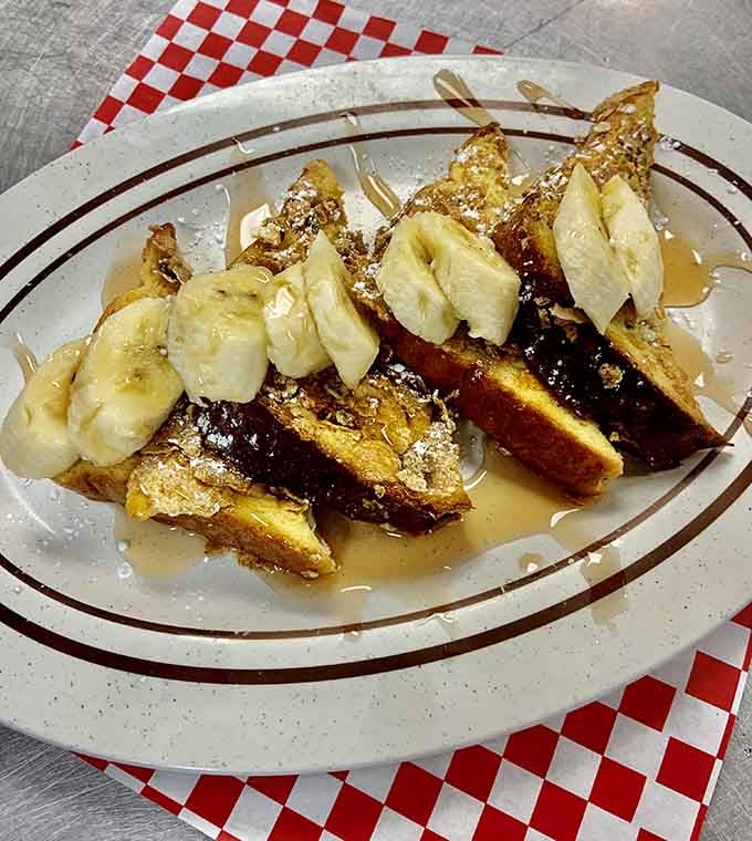 French toast topped with bananas and dusted with powdered sugar &ndash; breakfast dessert that's totally acceptable before noon.