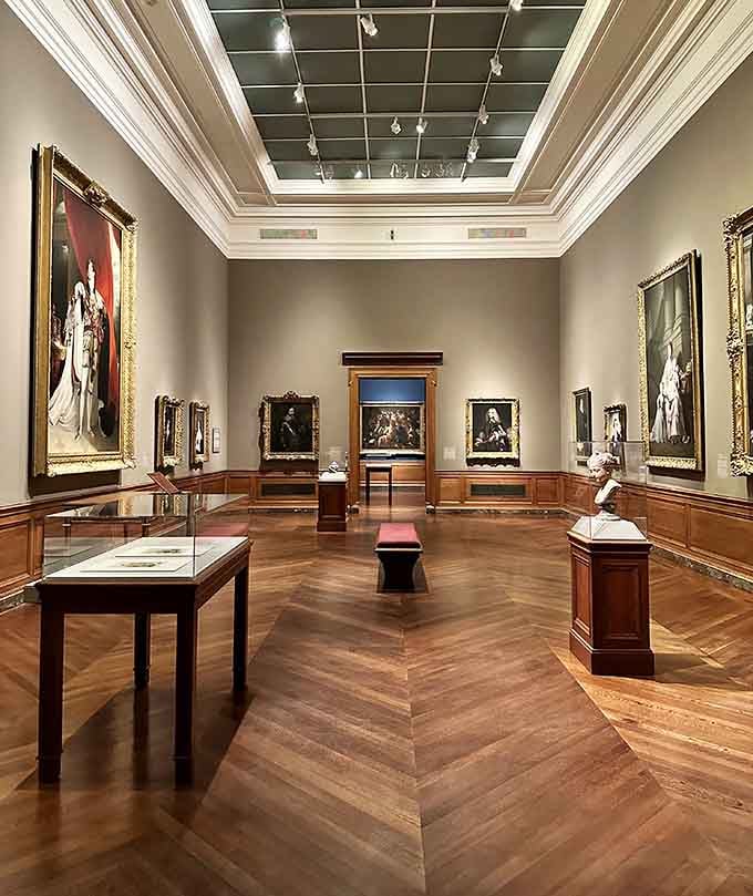 Classic gallery spaces with herringbone floors where Old Masters meet sculptures in perfect museum harmony.