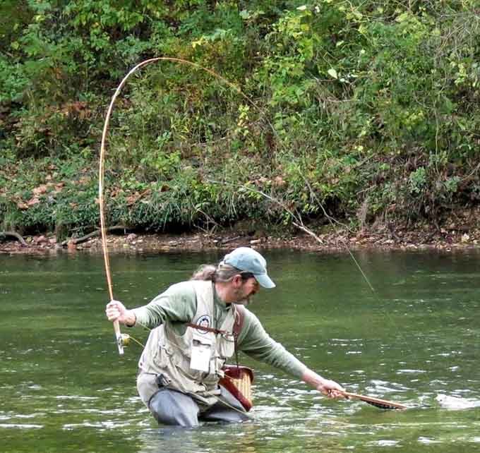 Knee-deep in spring-fed clarity, this angler's practicing the ancient art of optimism with a side of rainbow trout.