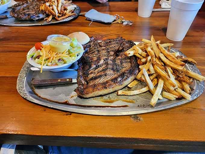 A sirloin this massive with crispy fries and fresh salad is basically a complete food pyramid on one platter.