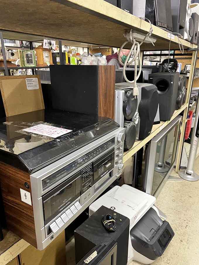 Vintage electronics and modern gadgets share shelf space, creating a technological time capsule that spans decades of innovation.