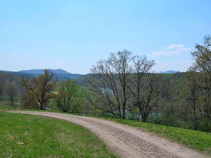 That dirt road winding through green hills? Your escape route from the 21st century's chaos.