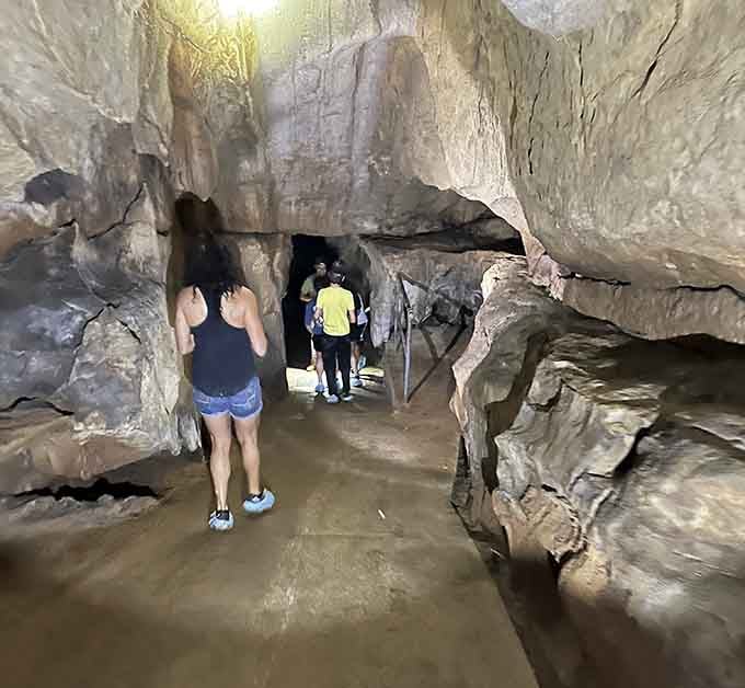 Wide passages welcome explorers into chambers where the ceiling soars and formations stand like sentinels guarding ancient secrets below.