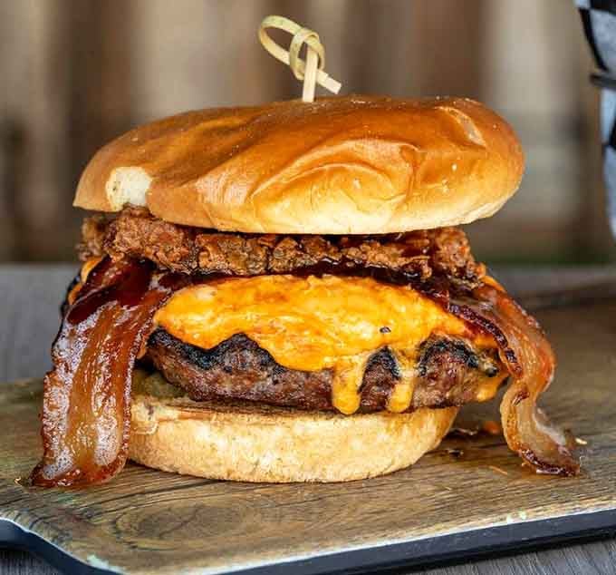 The Pimento Pub Burger arrives with a pretzel bun crown, because regular buns clearly weren't ambitious enough for this operation.