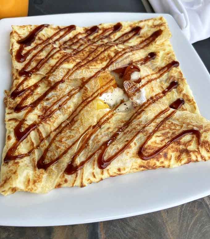 That golden crepe holds an egg like a treasure, proving breakfast can be both elegant and filling.