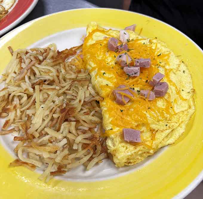 Fluffy eggs and crispy hash browns on a sunny yellow plate, breakfast never looked this cheerful.