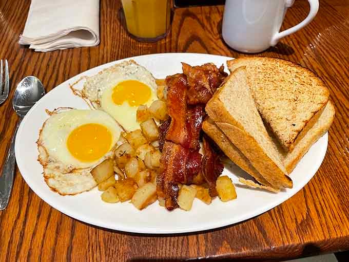 Two sunny-side-up eggs staring back at you like they're daring you to finish everything on this glorious plate.