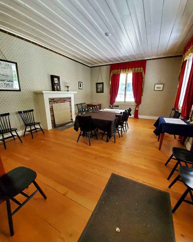Red curtains and wooden chairs, proving that 1850s interior design was all about practical elegance.