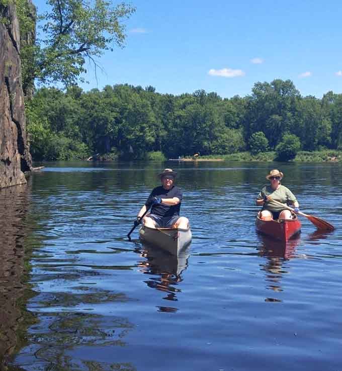 Paddlers glide across calm waters where the only traffic jam involves deciding which direction looks prettier.