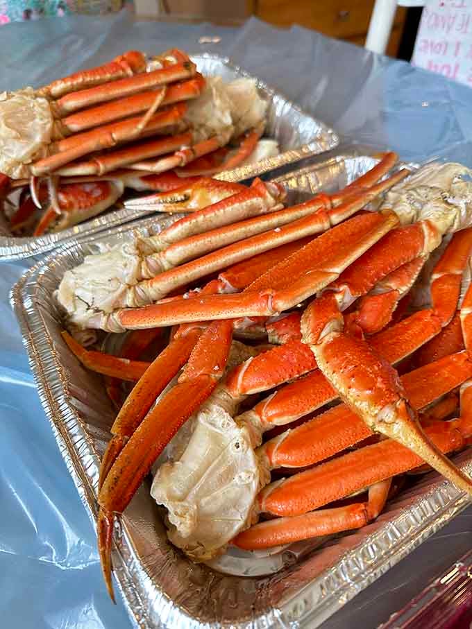 Snow crab legs piled high in foil trays, ready to make someone's dinner party the talk of the neighborhood.