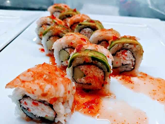 Sushi rolls dressed up with avocado and drizzled sauce, proving that buffet sushi can absolutely hold its own.