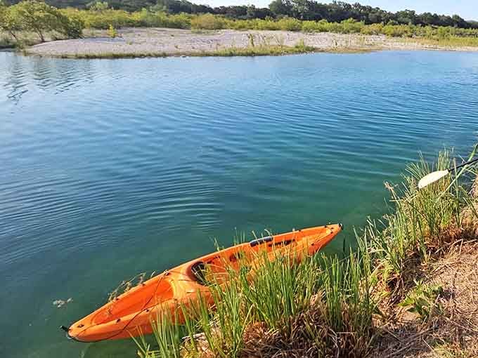That orange kayak is ready for adventure on water that looks suspiciously like a screensaver come to life.