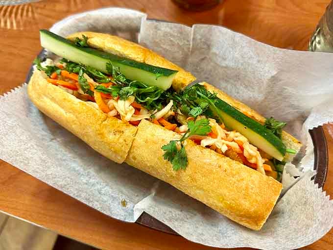 Behold the b&aacute;nh m&igrave; in all its glory: crispy bread, fresh herbs, and pickled vegetables creating sandwich perfection.