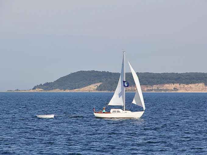 Sailboats gliding past the Manitou Islands, because sometimes the best therapy involves wind and water.