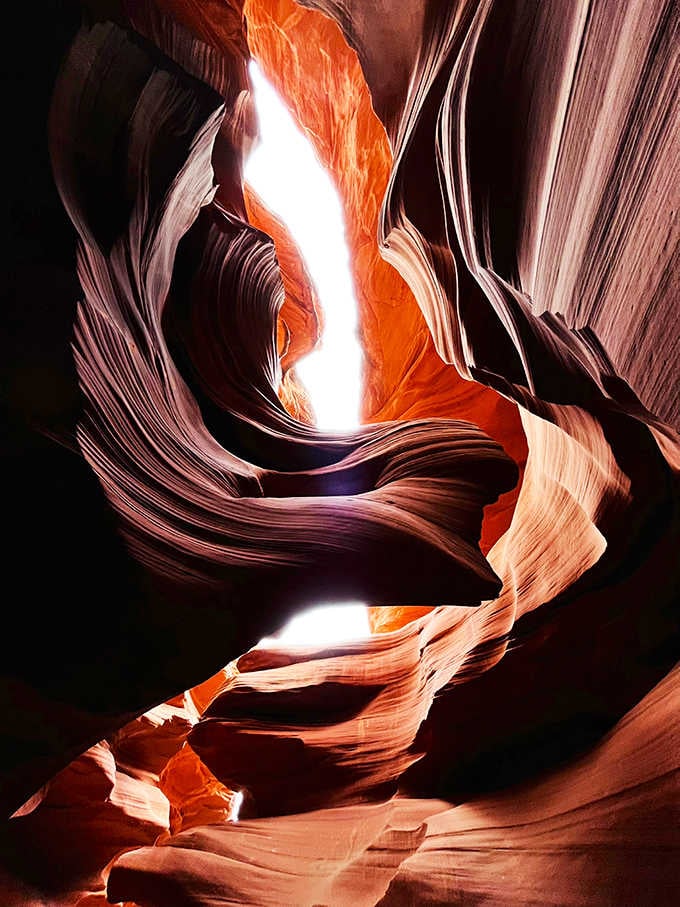 When light pierces the darkness, the canyon transforms into a cathedral that would make Michelangelo reconsider his career choices.