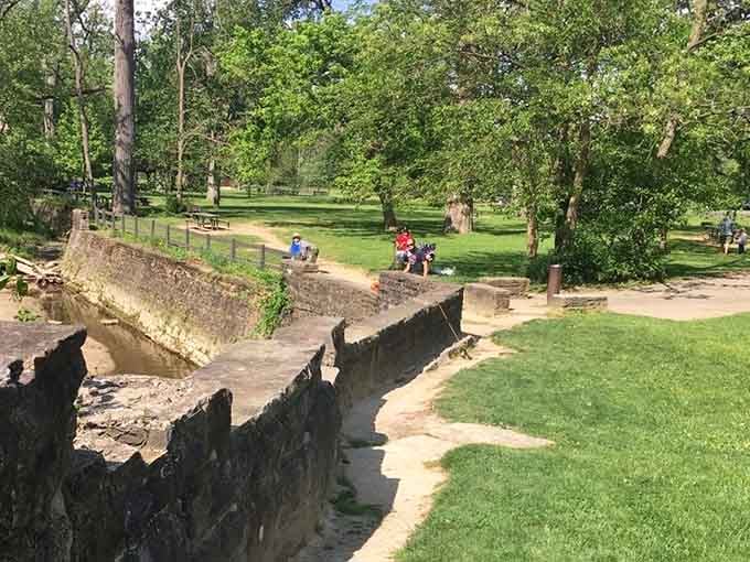 The old stone spillway creates a picturesque fishing spot that looks like a postcard from simpler times.