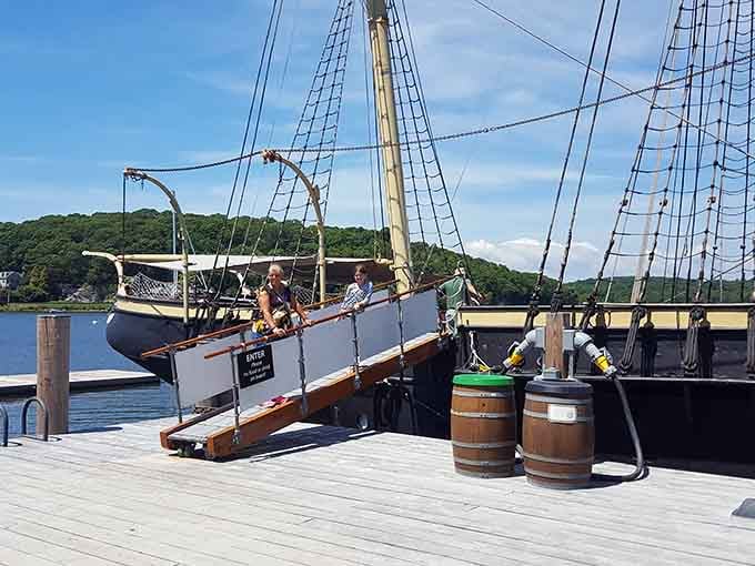 Visitors exploring a whaleboat, probably wondering how anyone fit in there for months at a time, honestly.