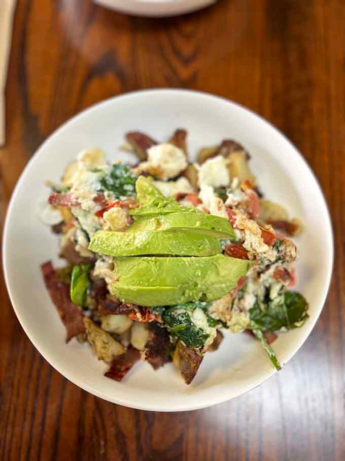 Fresh avocado crowning a breakfast bowl that somehow makes healthy eating look absolutely delicious and completely satisfying.
