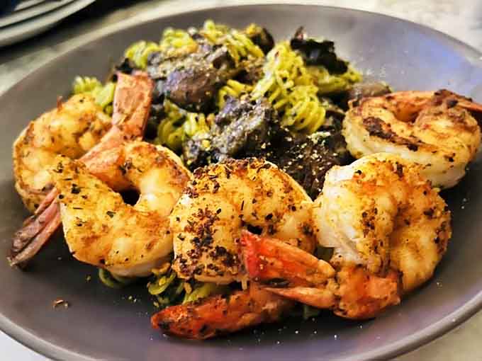Perfectly seasoned shrimp sitting on pasta like they're posing for their close-up&mdash;and honestly, they've earned it.