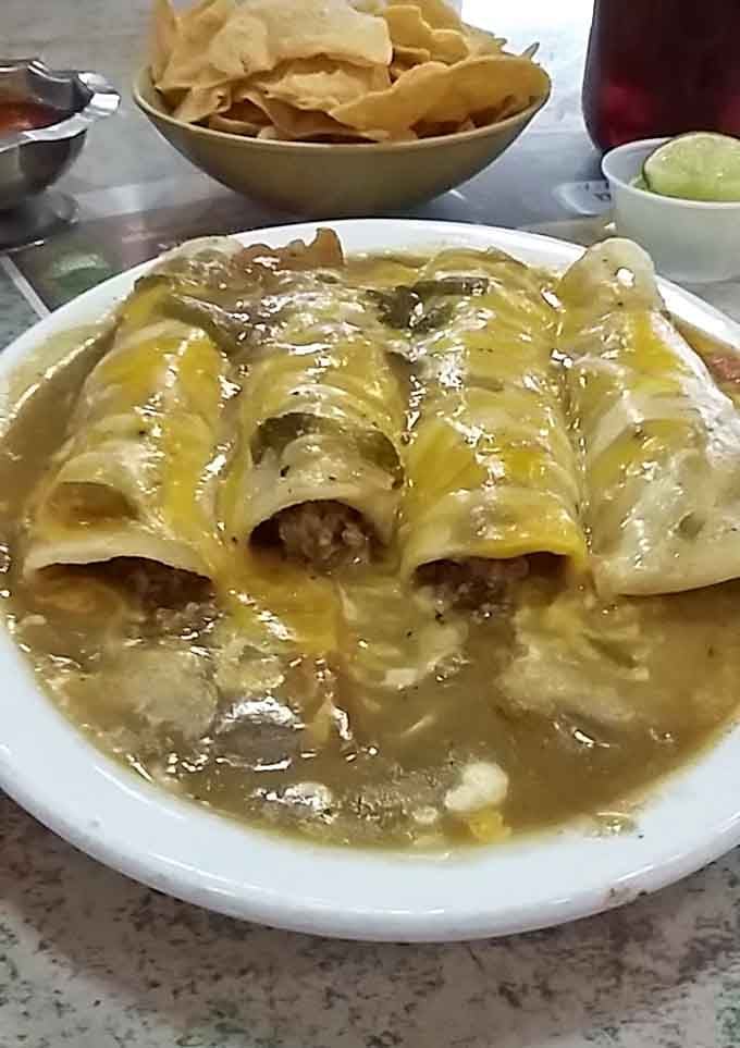 Beef enchiladas swimming in green chile sauce that'll make you forget every chain restaurant you've ever visited.