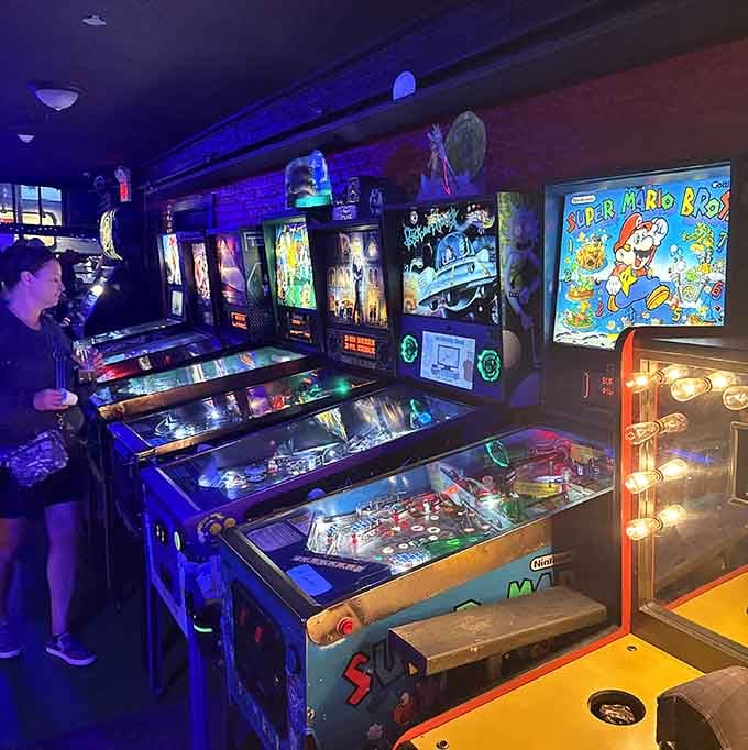 A wall of pinball machines glowing like a neon dream, each one ready to humble you in the best way.