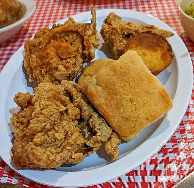 A plate loaded with fried chicken, cornbread, and a biscuit is basically the Texas version of winning the lottery.