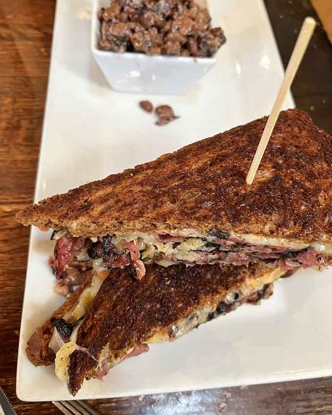 A perfectly grilled Reuben with what appears to be house-made accompaniments—this is sandwich architecture at its finest, folks.