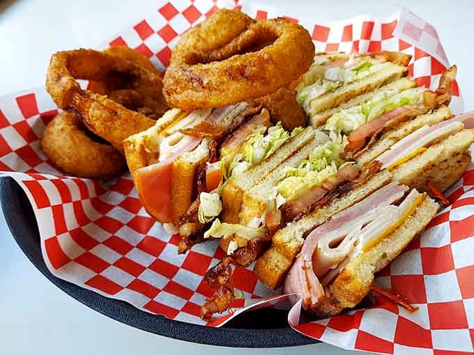 The club sandwich arrives stacked higher than your expectations, with onion rings that crunch like applause.
