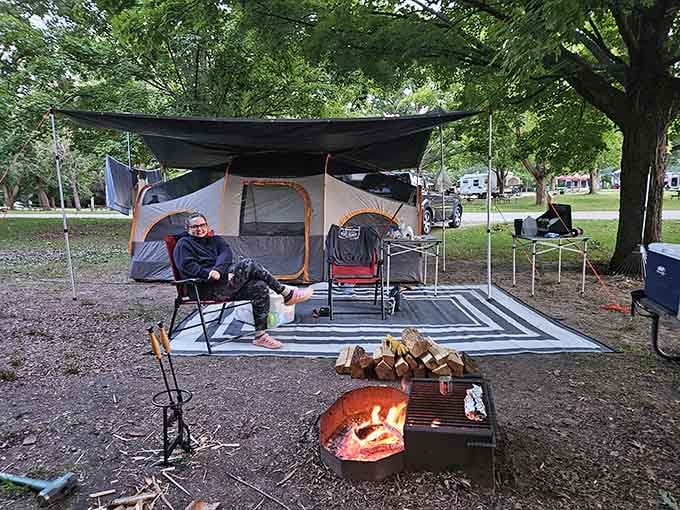 This camper's setup rivals any luxury resort, complete with crackling fire and enough firewood to last through storytelling season.