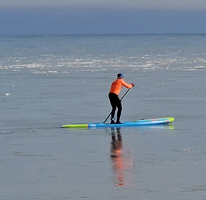Paddleboarding on glass-smooth water, because Lake Michigan occasionally decides to behave like a giant peaceful pond.