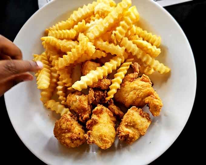 Those crinkle-cut fries paired with perfectly crispy chicken tenders are basically edible happiness on a plate.