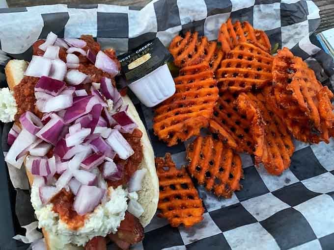 Carolina Dog topped with chili and onions alongside waffle fries proves that simple pleasures are often the best.